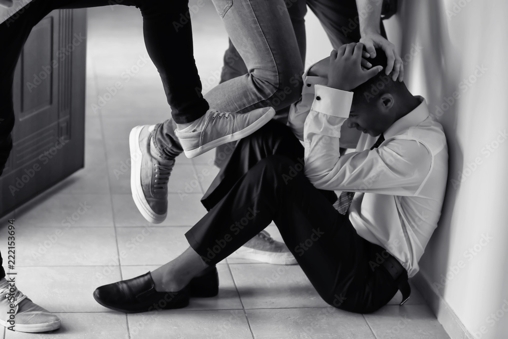 Teenagers bullying African-American boy at school Stock Photo | Adobe Stock