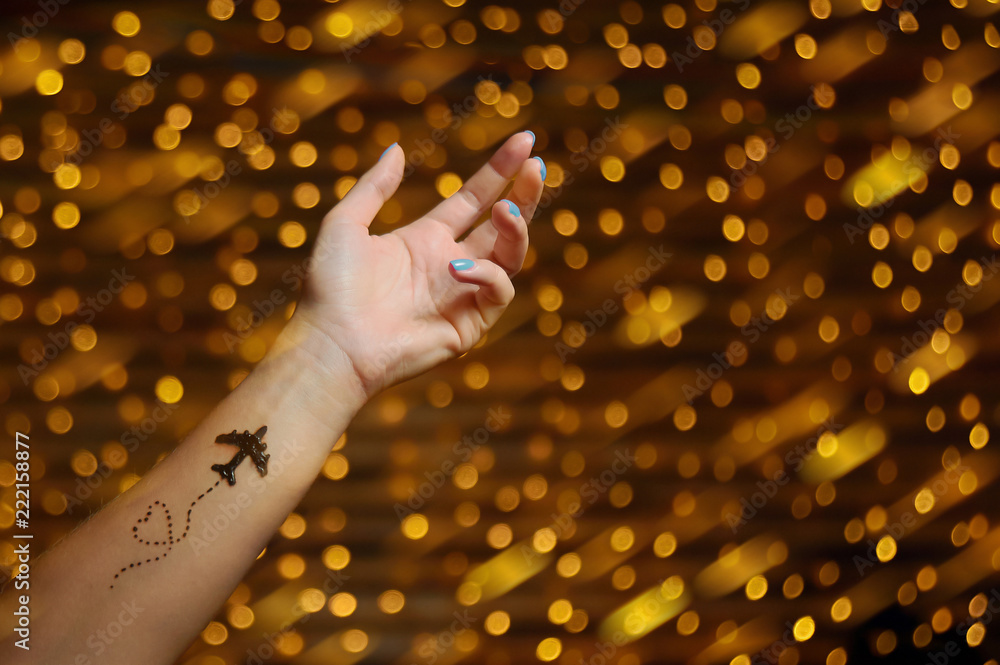 hand with plane and heart tattoo at blurred garland background ...