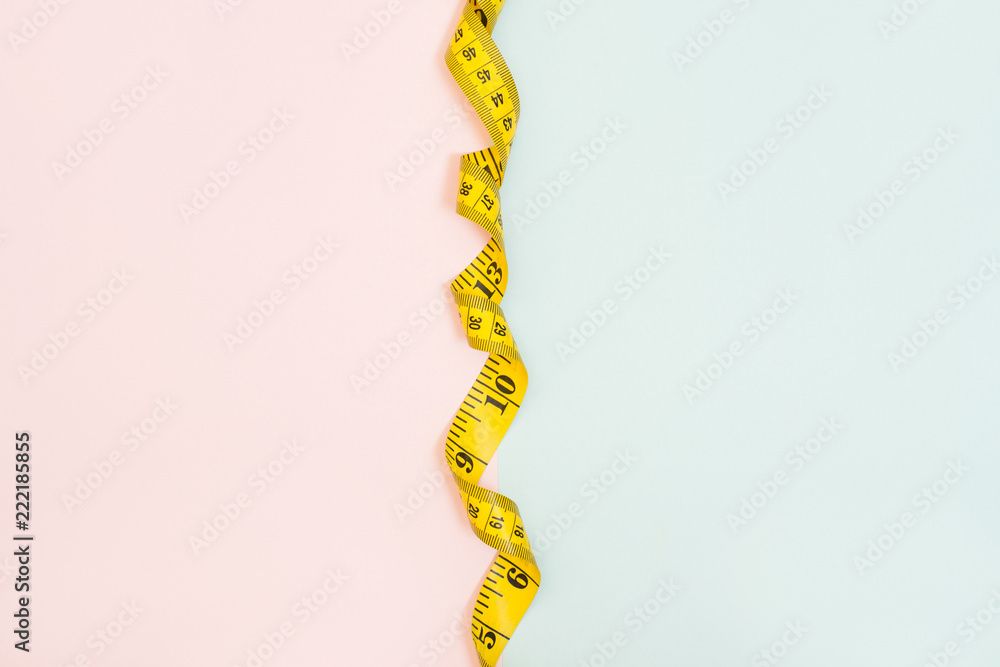 Half light pink half light blue background with tape measure in the ...