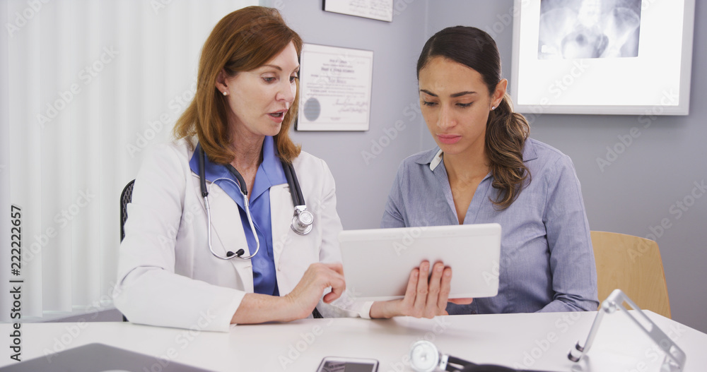 Senior medical physician using high-tech tablet to share lab results ...