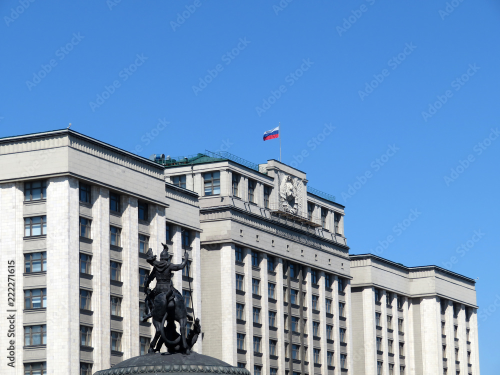 Parliament building in Moscow against clear blue sky. Russian flag on ...