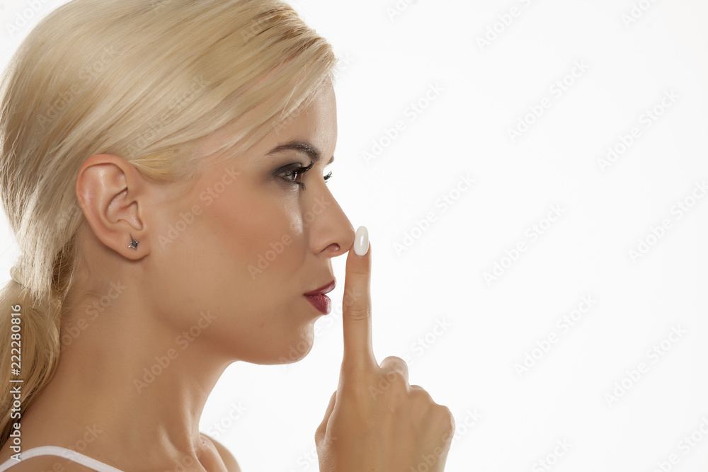 Profile of beautiful girl with finger over her lips on white background ...