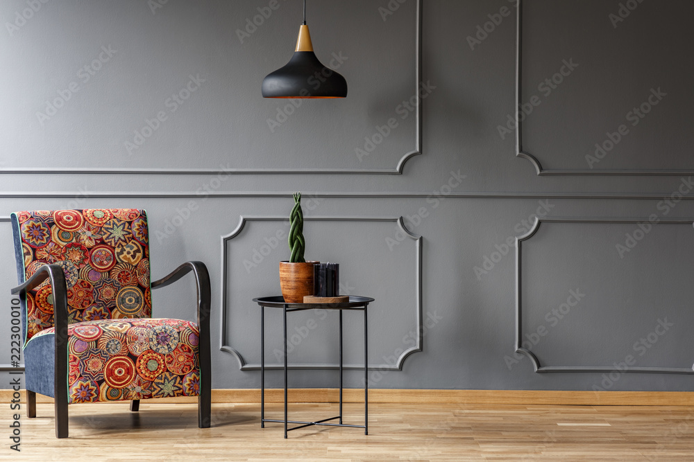 Black ceiling light above an industrial side table with a plant and an ...