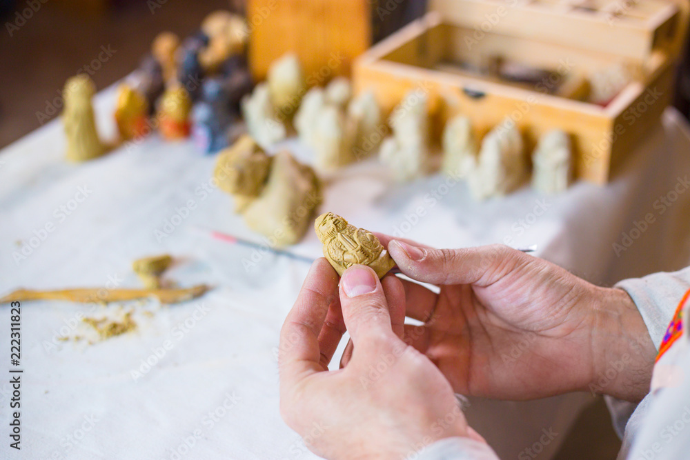 Professional male potter making clay figure for medieval popular ...