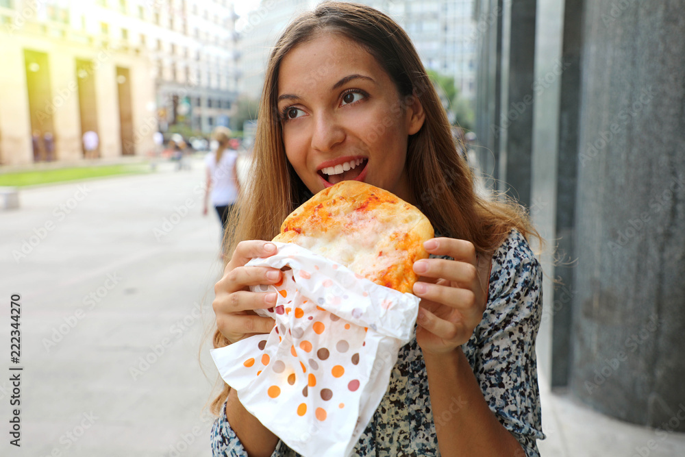 Happy young business woman eating a small pizza in her short lunch ...