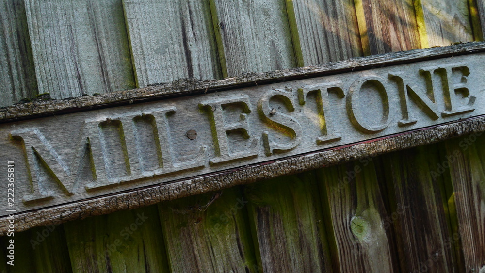 Weathered wooden milestone sign on slatted door / fence panel Stock ...