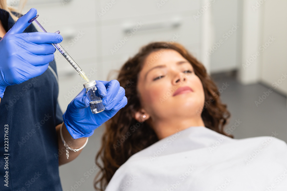 Attractive young woman is getting a rejuvenating facial injections. She ...