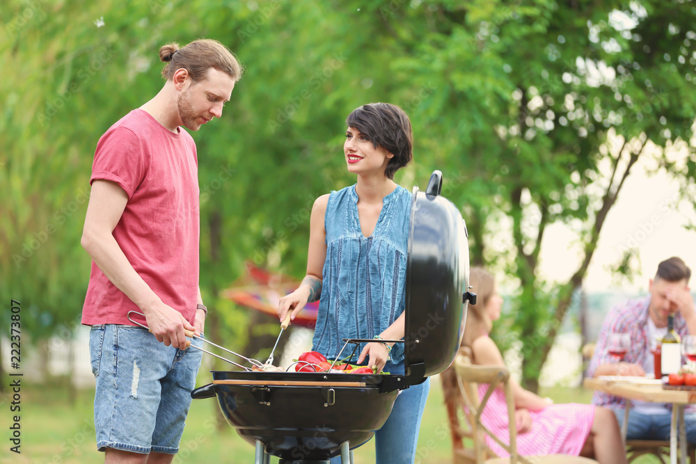 Young people having barbecue with modern grill outdoors Stock Photo ...