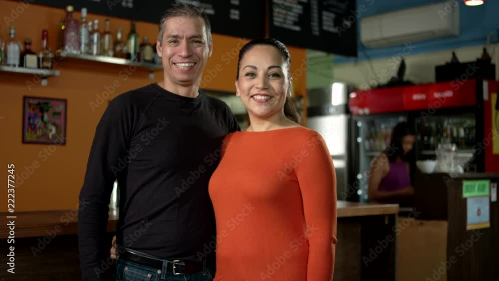 Portrait of a smiling hispanic couple and their family working in their ...