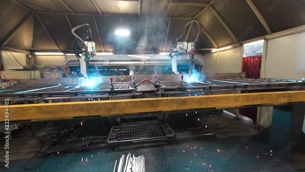 Robot welder welds the profile on the welding table at the factory ...