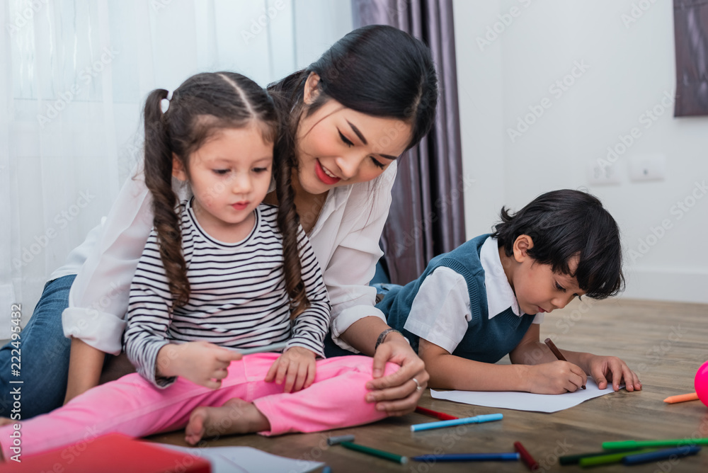 Mother teaching children in drawing class. Daughter and son painting ...