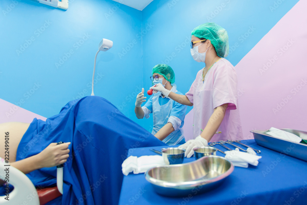 Maternity ward,obstetrician and nurse to the patient lying on a bed in ...