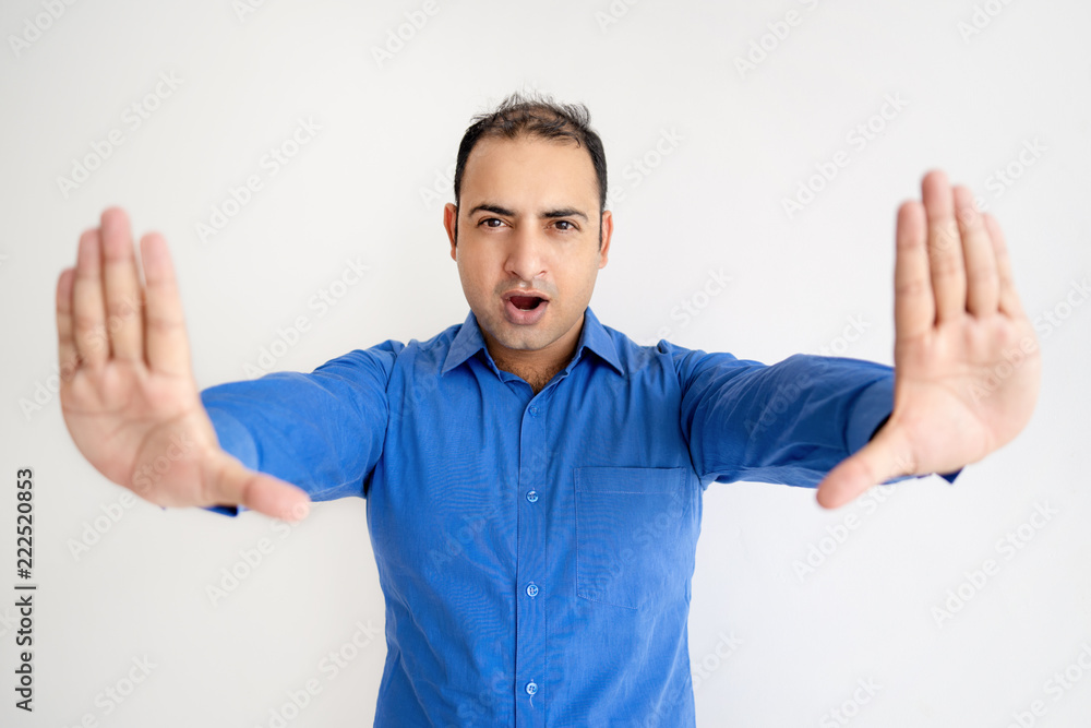 Serious Indian man showing stop gesture with palms. Young guy screaming ...