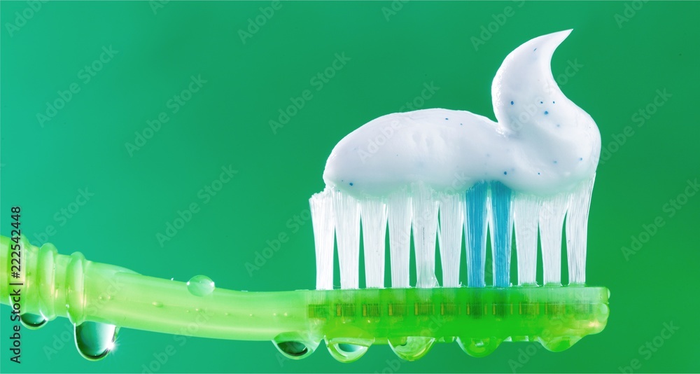 Toothpaste on a toothbrush on background Stock Photo | Adobe Stock