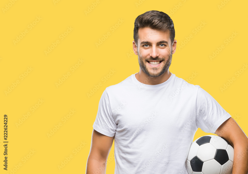 Young handsome man holding soccer football ball over isolated ...