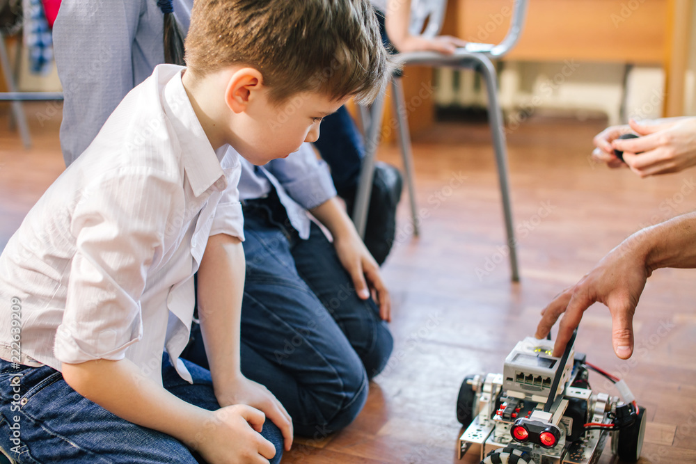 Little boy in robotics school makes robot managed from the constructor ...