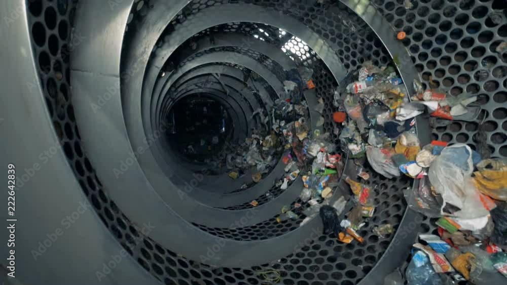 Lots of trash in a recycling center. Recyclable garbage rotates in a ...