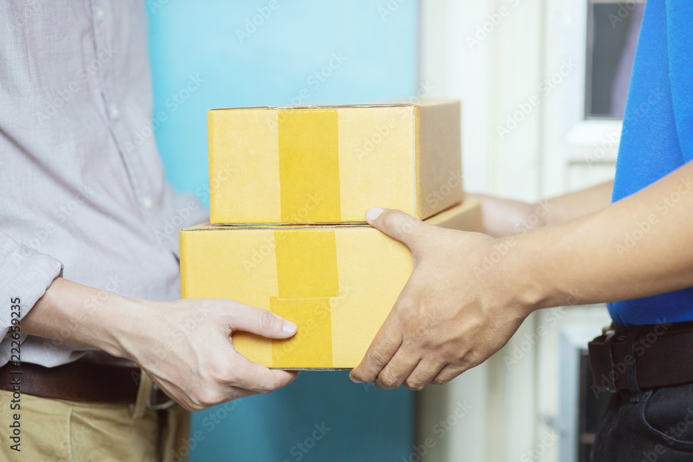parcel delivery man of a package through a service. and close up hand ...