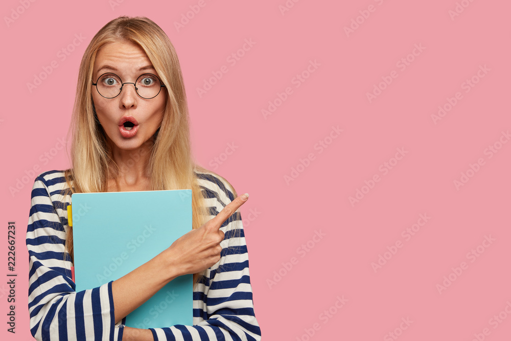 Horrified Caucasian teacher holds textbook, being shocked with bad ...