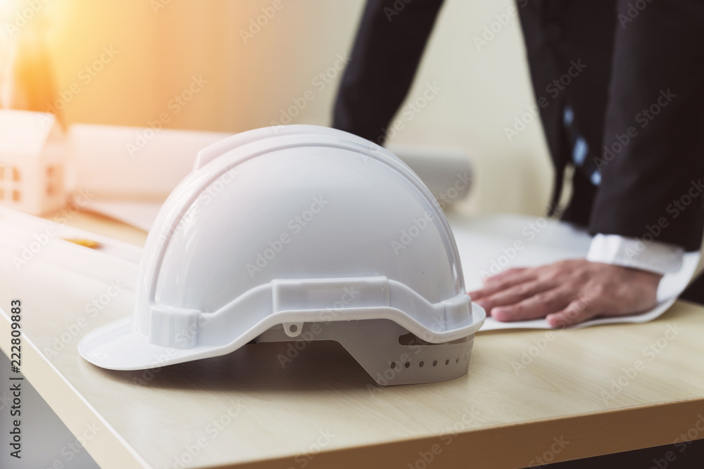 Engineer safety white helmet on work table and manager looking in ...