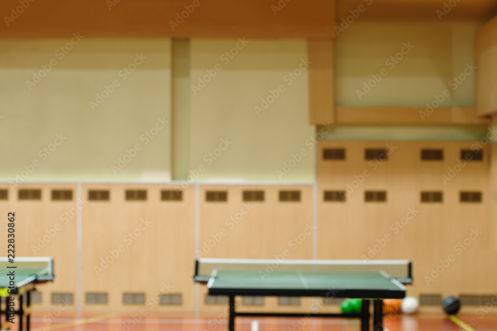 Naturally blurred interior of modern gym with tables for ping-pong ...