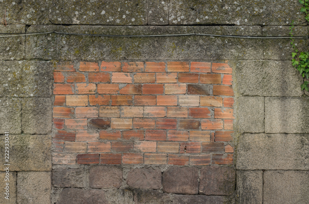 Puerta tapiada con ladrillos en muro de piedra Stock Photo | Adobe Stock