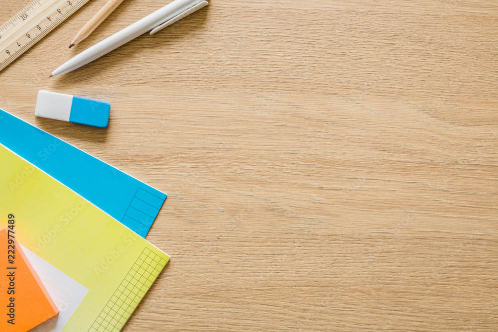 Exercise books, pen, pencil, ruler and eraser on the wooden work table ...