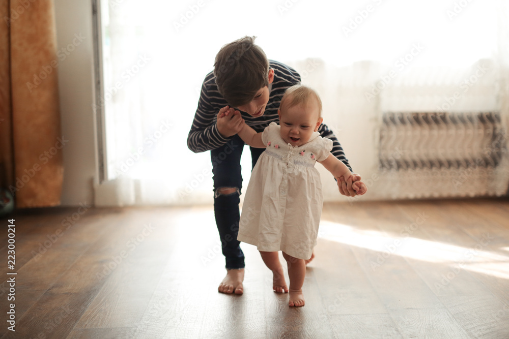 Cute big brother teen help him sister toddler Stock Photo | Adobe Stock