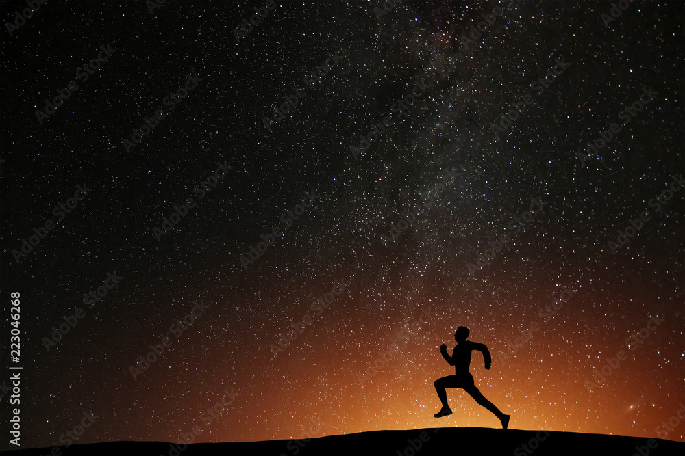 Runner athlete running on the hill with beautiful starry night ...