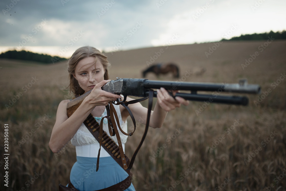 Portrait of a beautiful female cowgirl with shotgun from wild west ...