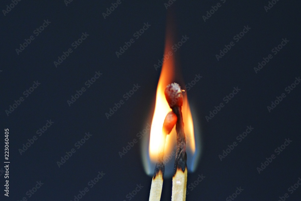 Two burning matches against a black background look like a couple ...