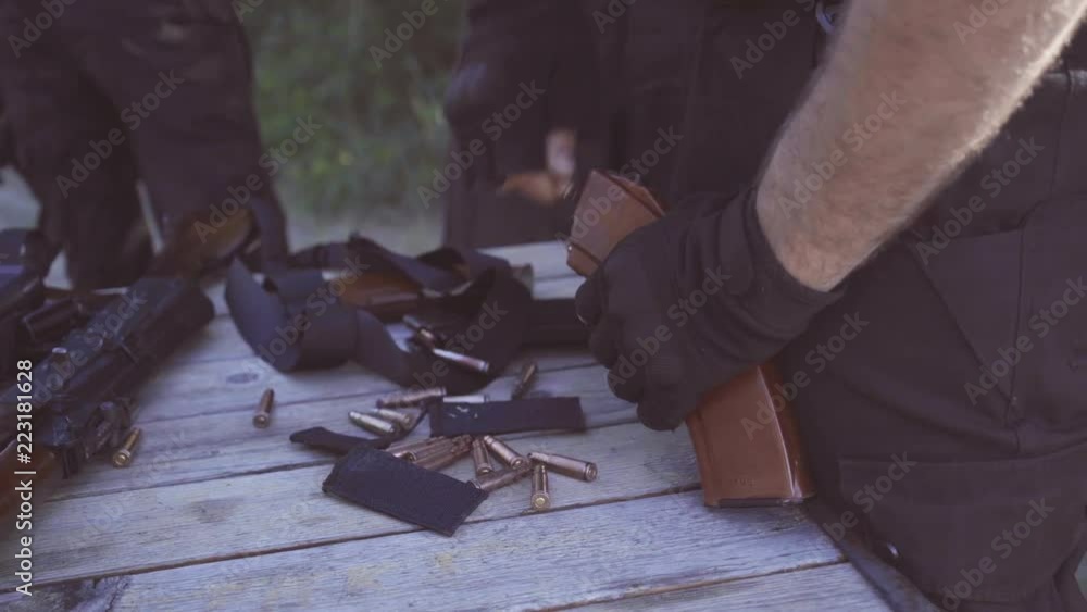 The security guard puts bullets into the magazine for machine gun and ...