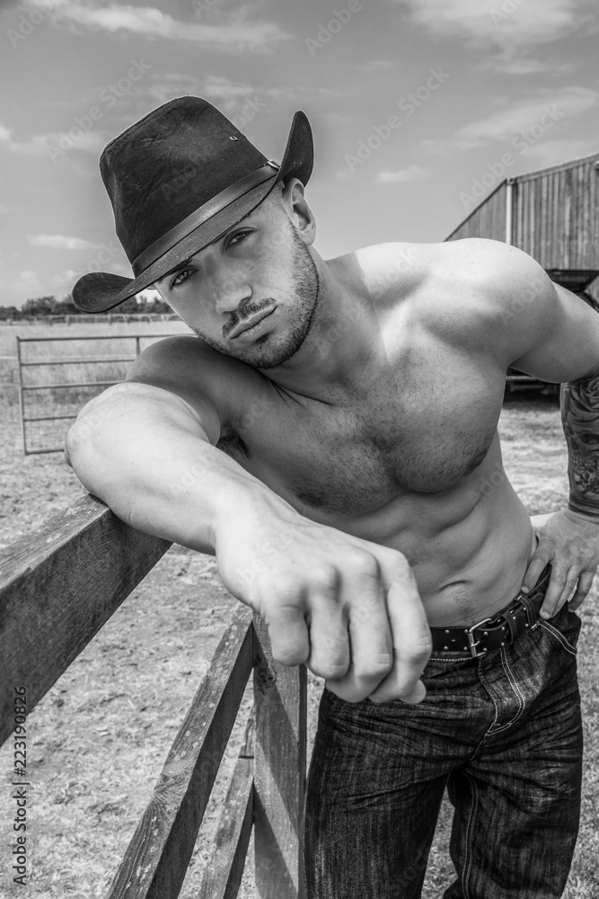 Sexy, handsome, hunky shirtless cowboy with hat abs and pecs looks at ...