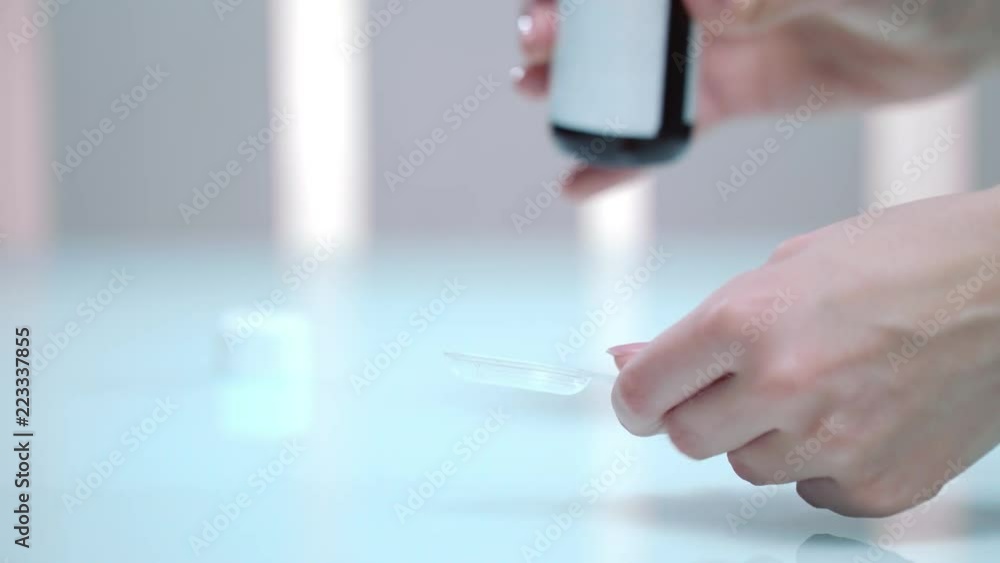 Woman hand pouring medicine syrup from bottle. Close up of female hand ...