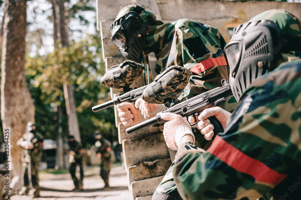 Foto de selective focus of paintball player in protective mask holding ...