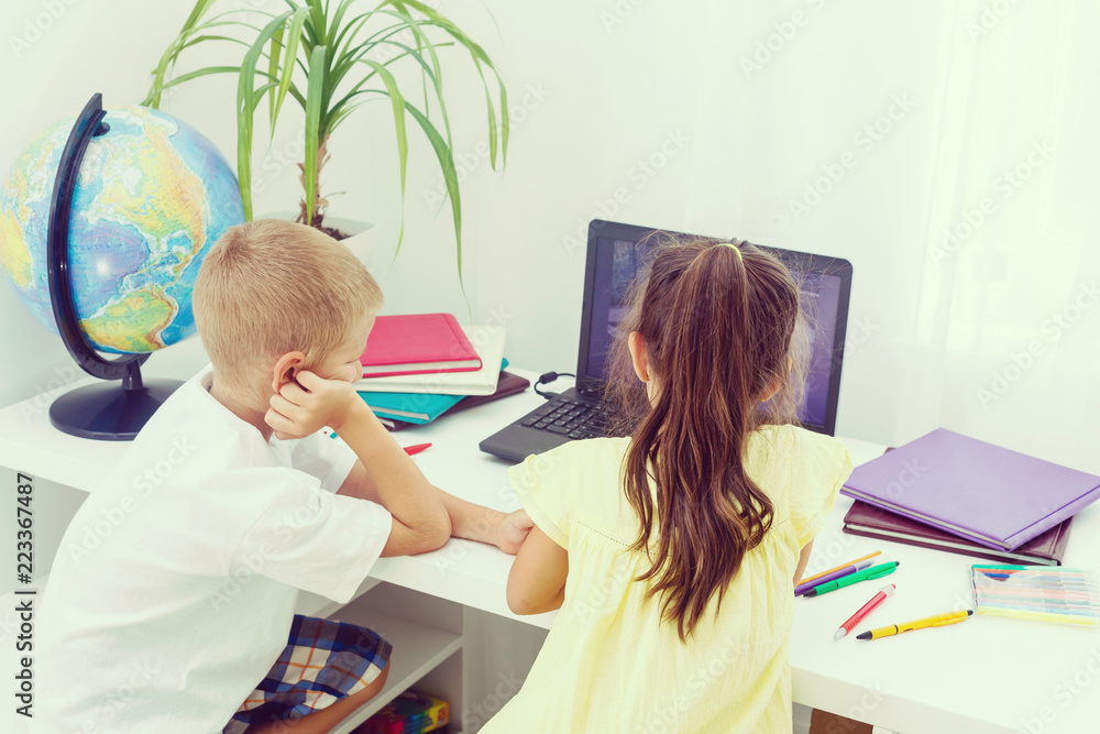 Cute little kids studying on study table with pile of books ...