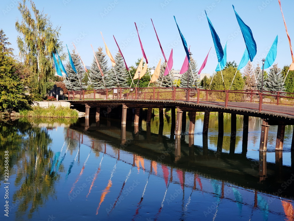 Multiple flags of a variety of brought colors in a footbridge across ...