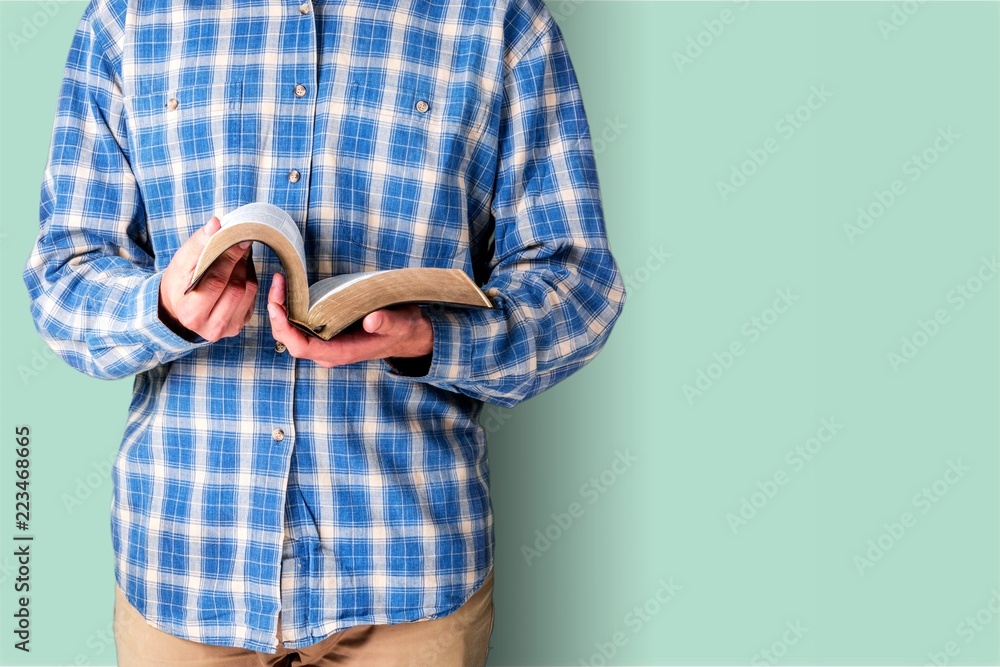 Man hand holding holy bible on background Stock Photo | Adobe Stock