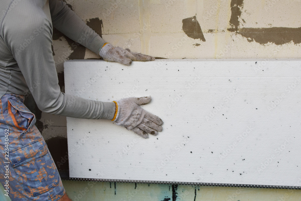 Man installing rigid styrofoam insulation board for energy saving on ...