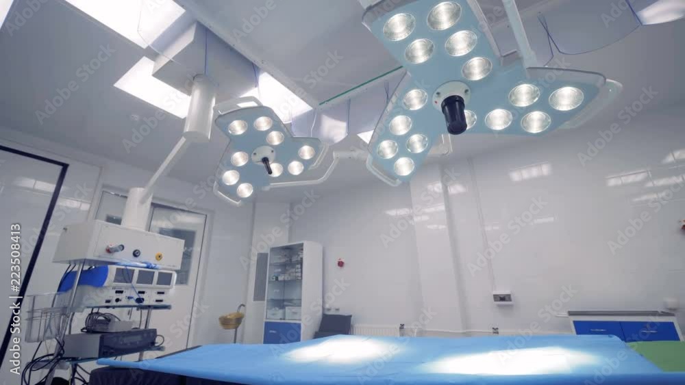 Two surgical lamps hanging above the bed in an operating room. Bright ...