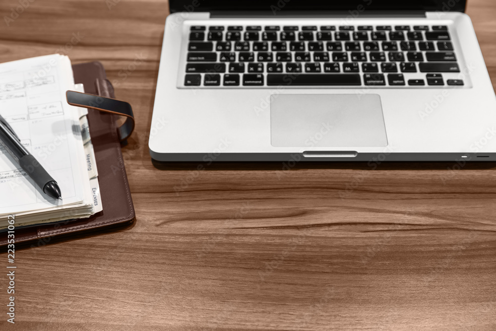 Office desktop. On the desk is a laptop, a notebook with notes and a ...