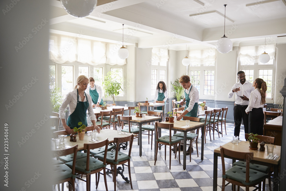 Staff Laying Tables In Empty Restaurant Stock Photo | Adobe Stock