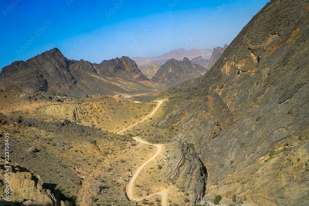 A mountain road winds over rocky hills between Nizwa and Rustaq in Oman ...