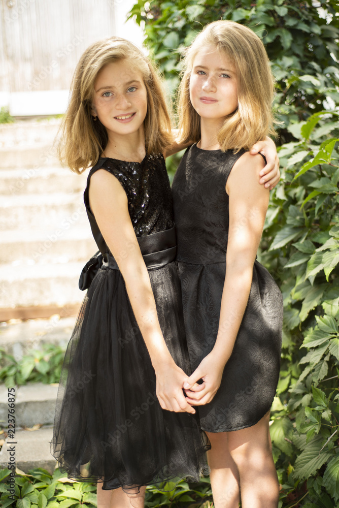 Twins sisters. Two cute and beatiful twins girls hugging each other and ...