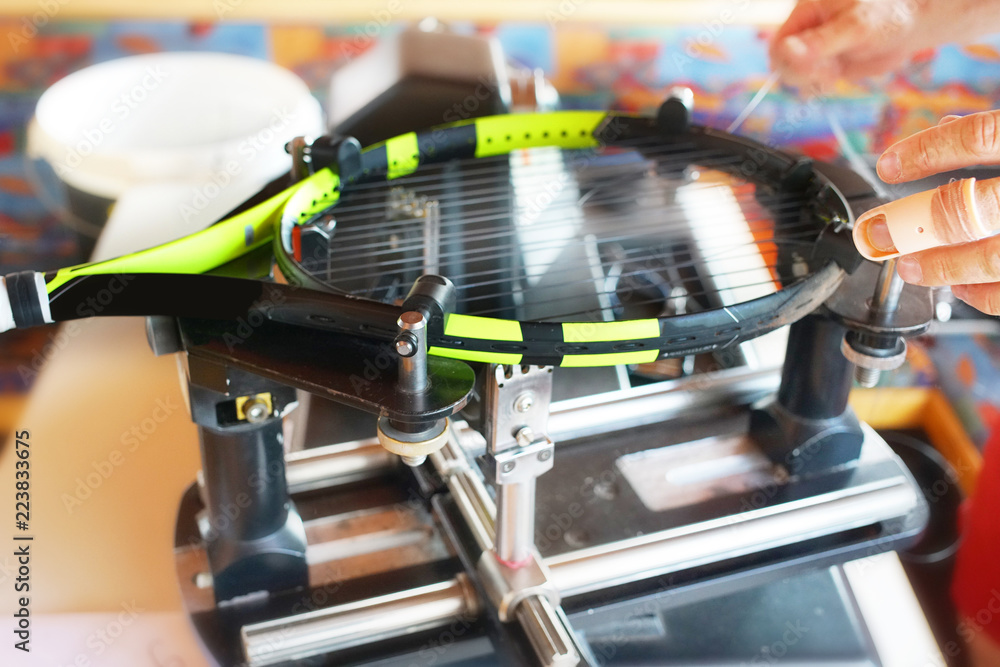 Stringer pulls strings on a tennis racket on equipment Stringing ...