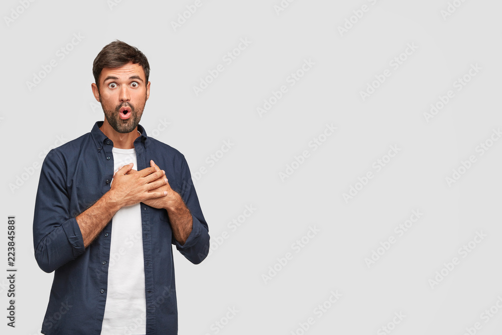 Stunned emotive unshaven man with shocked expression, keeps both palms ...