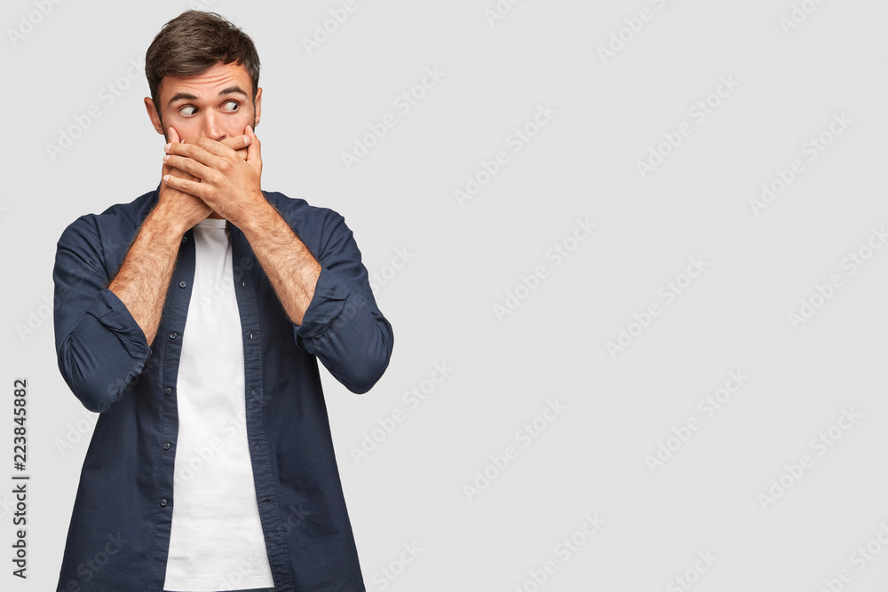 Foto Stock Waist up portrait of handsome mute man covers mouth with ...
