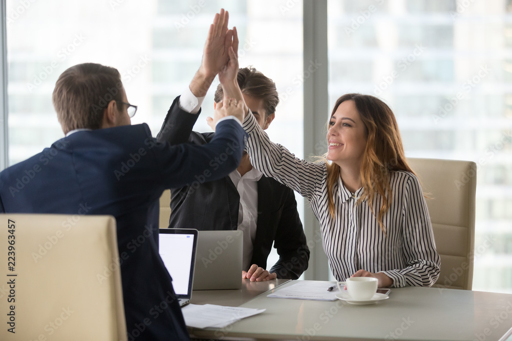 Smiling company workers giving high five motivating for future project ...