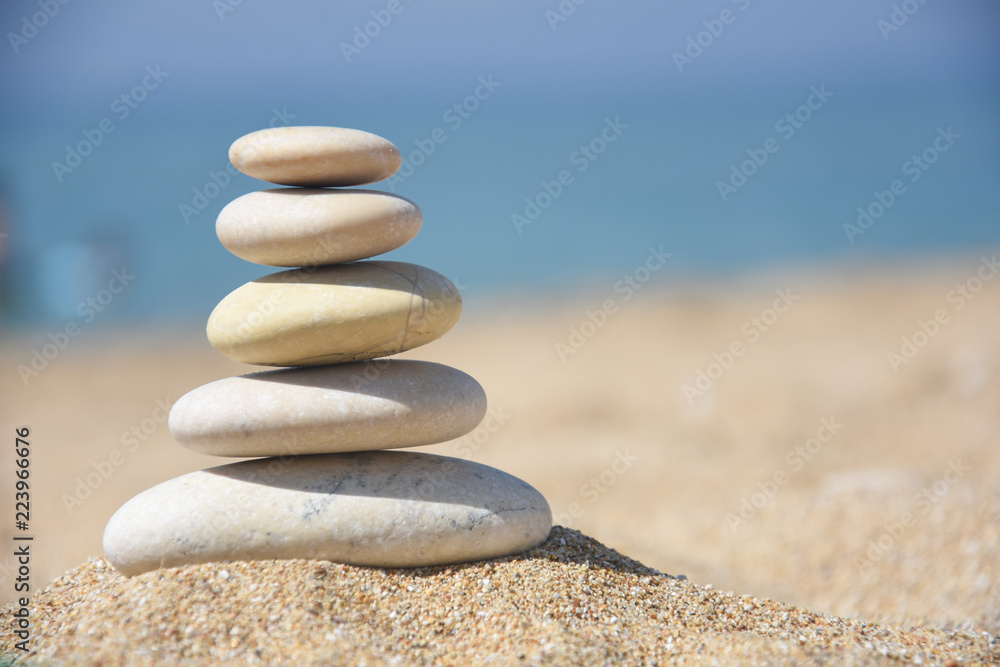 Balanced stone pyramid on sand on beach. Zen rock, concept of balance ...