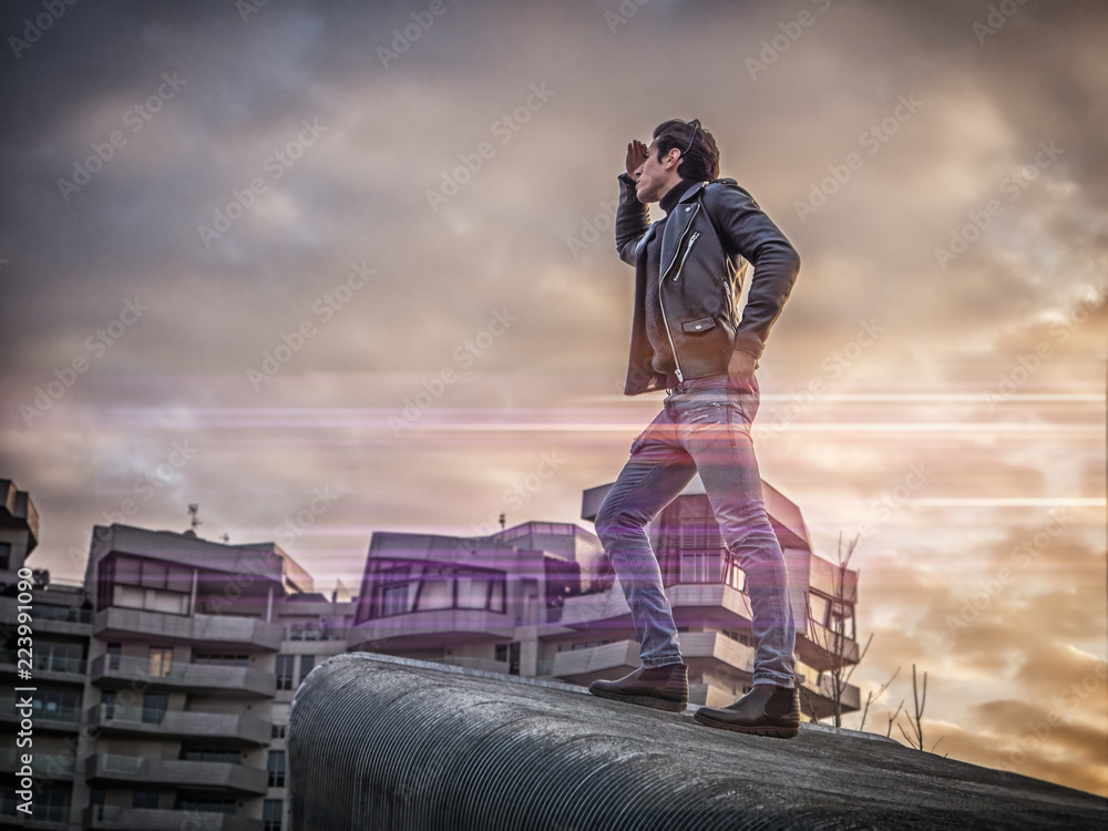 One handsome young man in urban setting in modern city, looking far ...